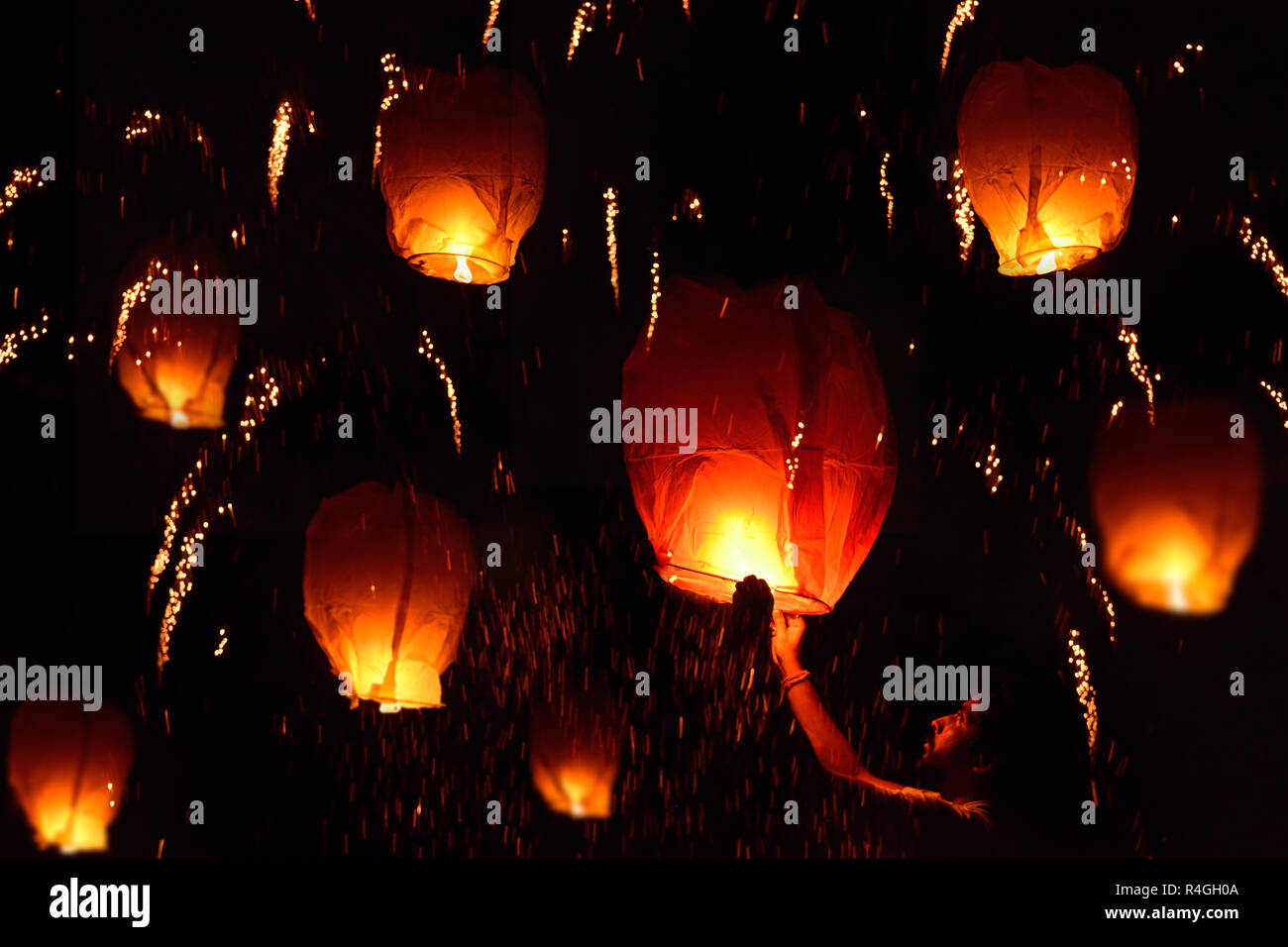 Man holding flying fire lantern to celebrate festival in a night ...