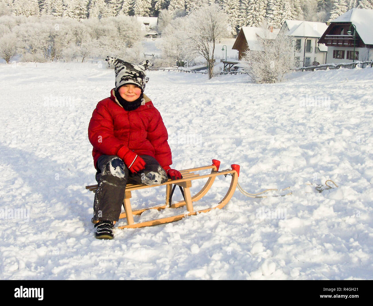 boy sitting on his sledge Stock Photo - Alamy