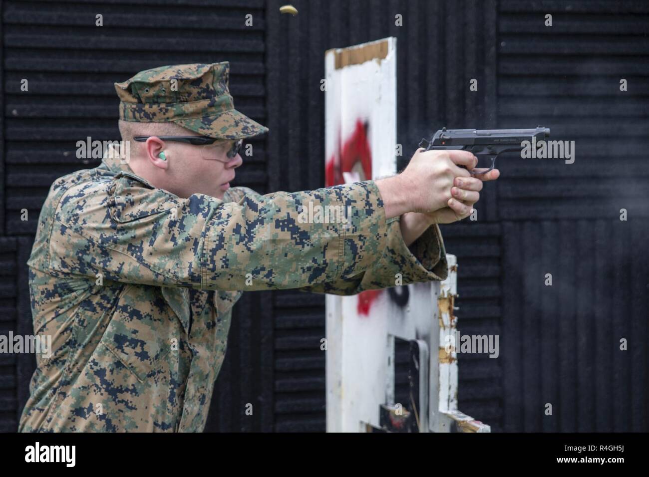 U.S. Marine Corps Pfc. Dulon Grant fires an M9A1 9mm service pistol ...