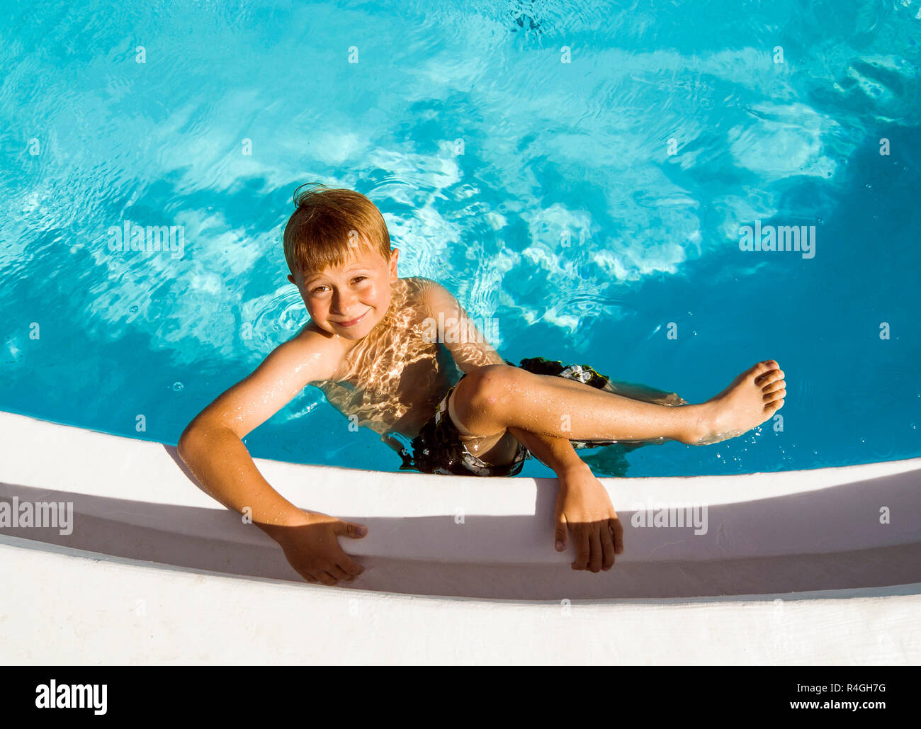 cute boy in swimming pool laughes and poses Stock Photo - Alamy