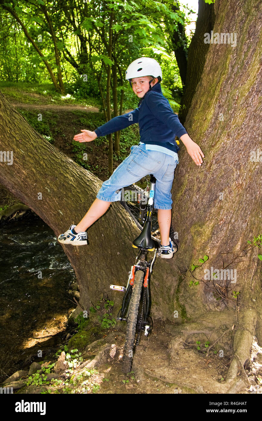 young boy with helmet is riding mountain bike Stock Photo - Alamy