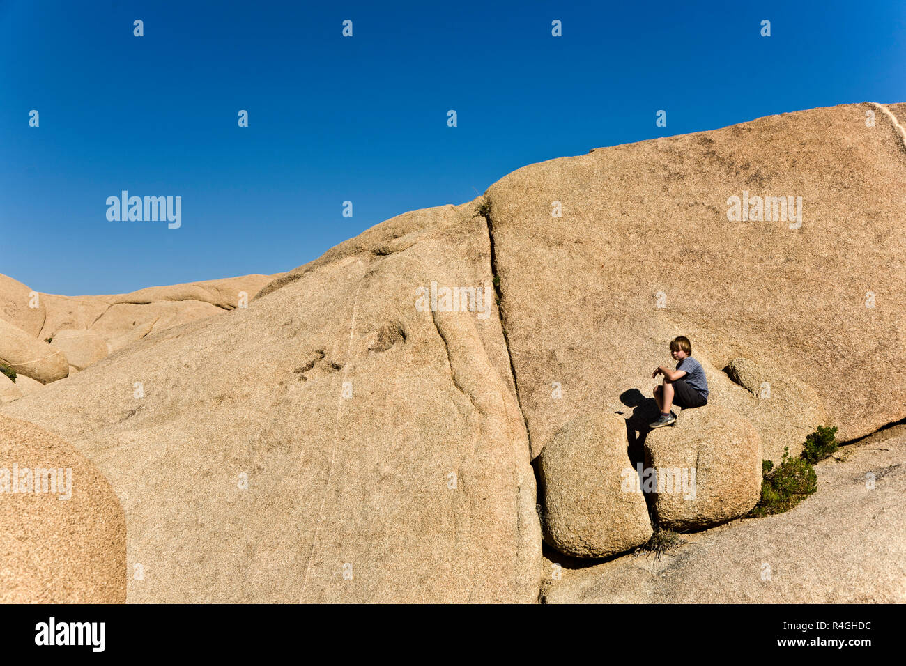 boy sitting on a rock Stock Photo - Alamy