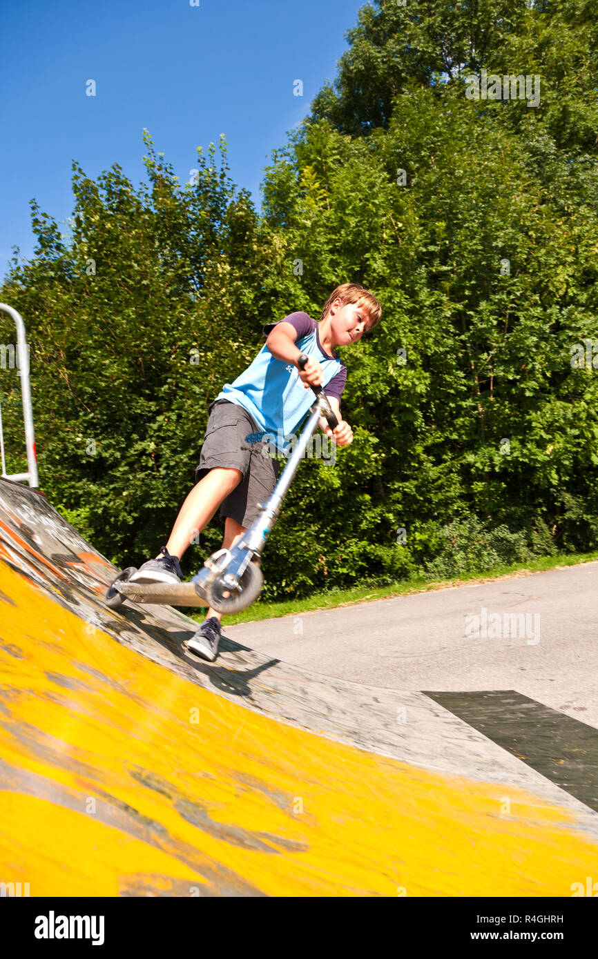 boy has fun riding his scooter Stock Photo - Alamy