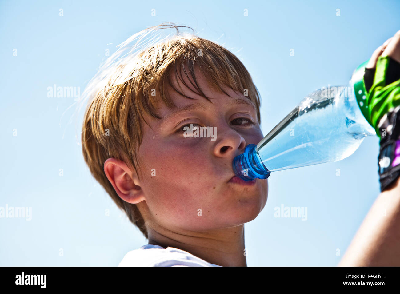 boy is sweating and thursty and drinks mineral water Stock Photo - Alamy