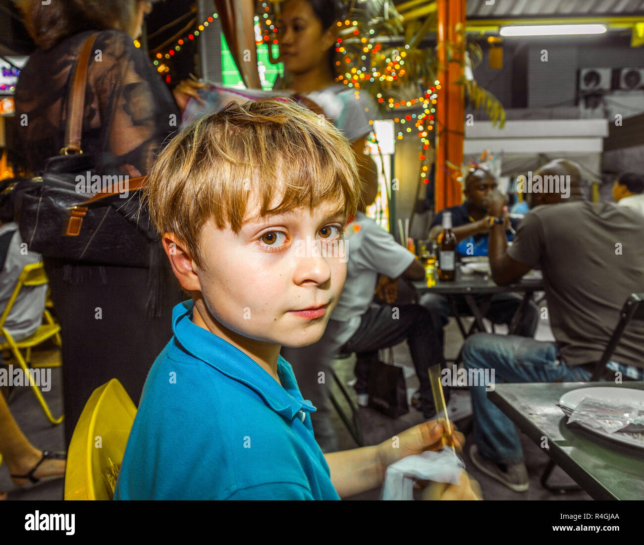boy enjoys eating at the night market Stock Photo - Alamy