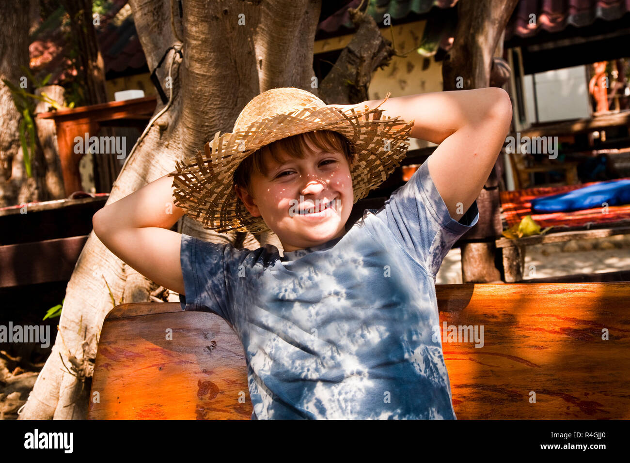 boy is relaxing, smiling and happy and has a rest in the sun at an open ...