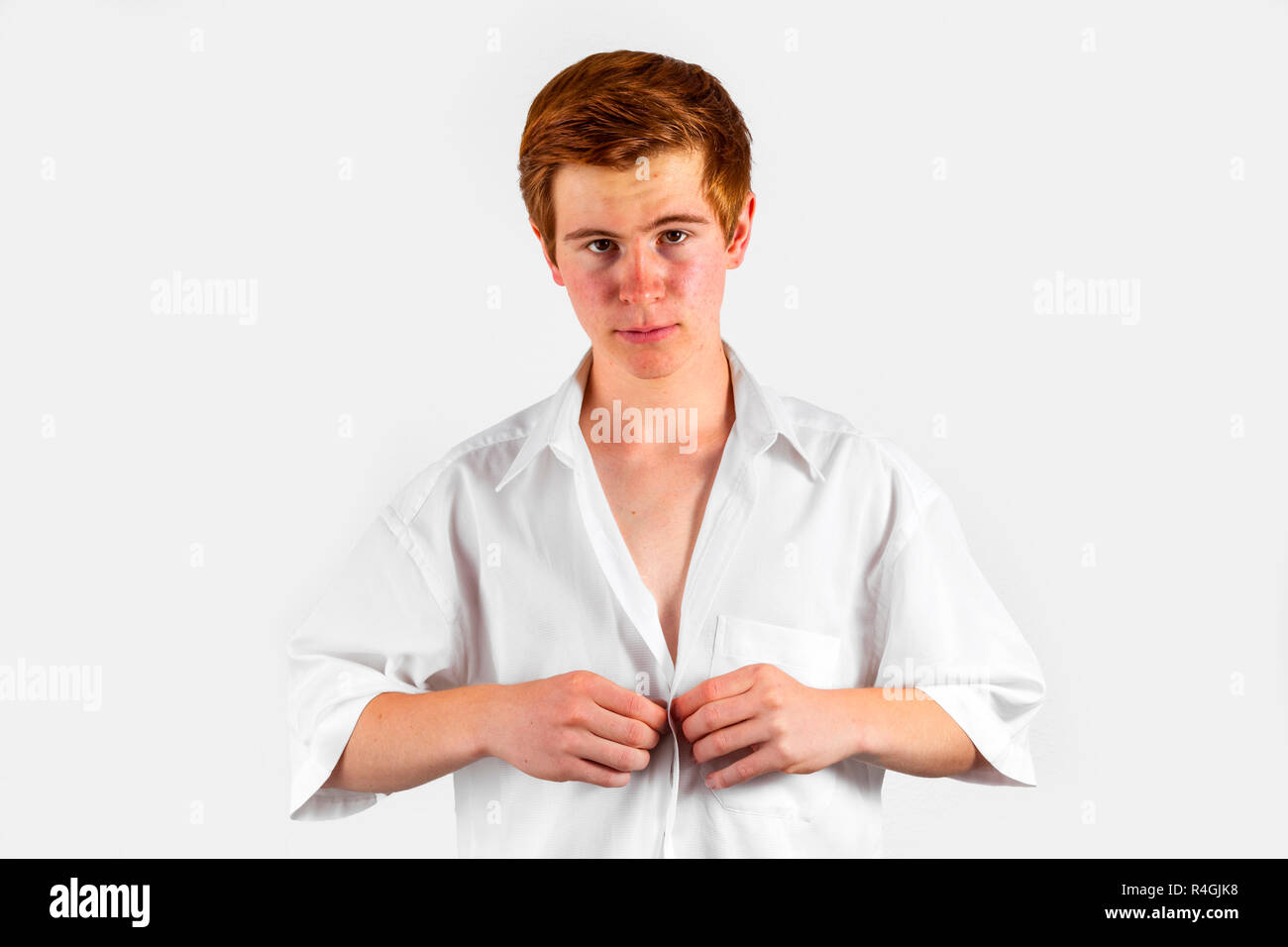 young man buttons his white shirt Stock Photo - Alamy