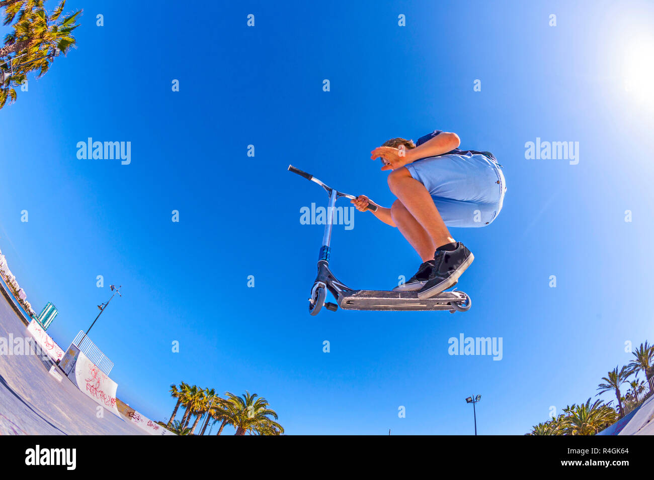 boy jumps with his scooter over a ramp Stock Photo - Alamy