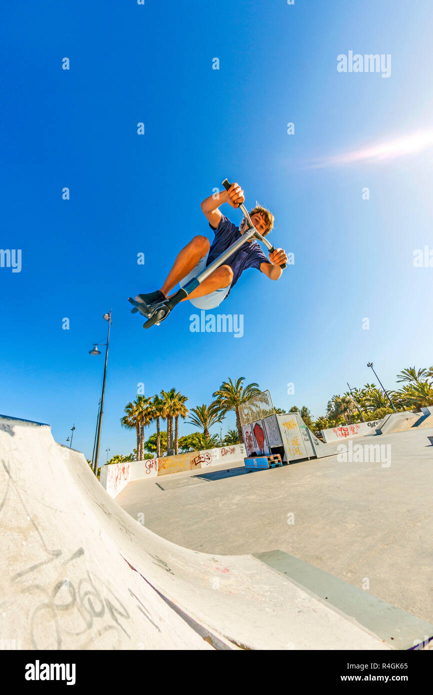 boy jumps with his scooter over a ramp Stock Photo - Alamy