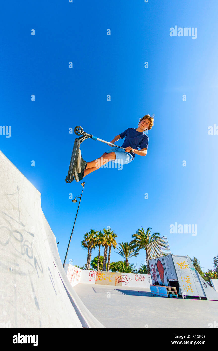 boy jumps with his scooter over a ramp Stock Photo - Alamy