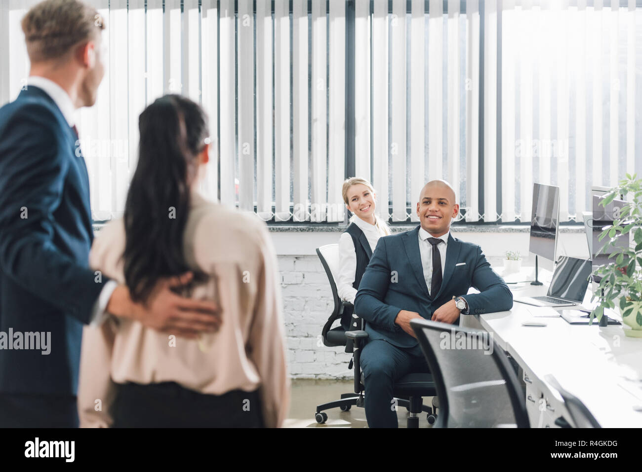 back view of businessman introducing new colleague to smiling young ...