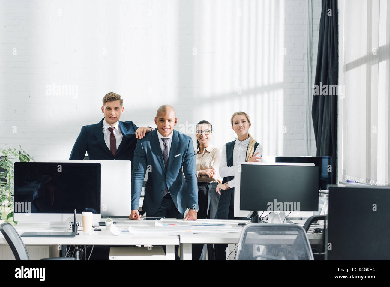 professional young multiethnic business team smiling at camera in open ...