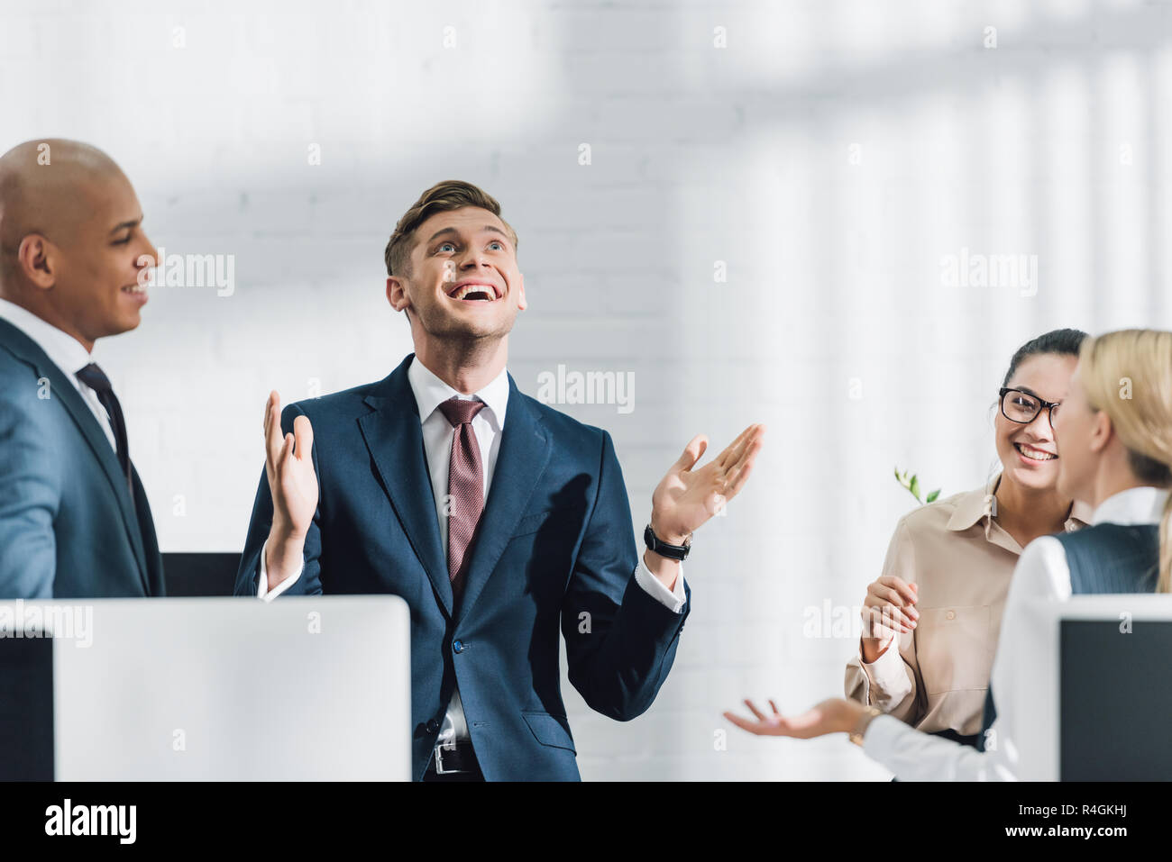 happy young business colleagues talking at workplace Stock Photo - Alamy