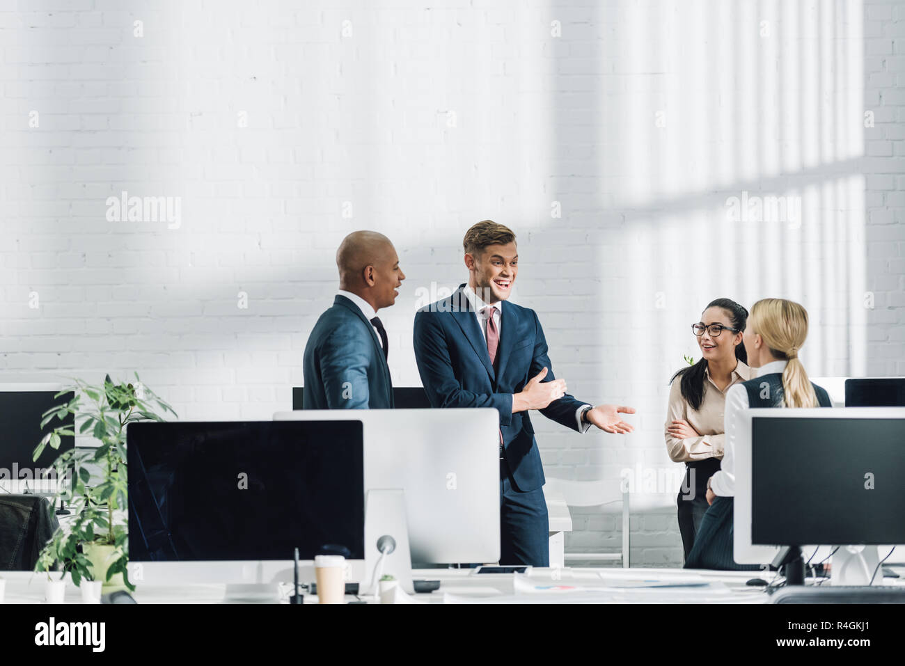 emotional young businessman talking with colleagues at workplace Stock ...