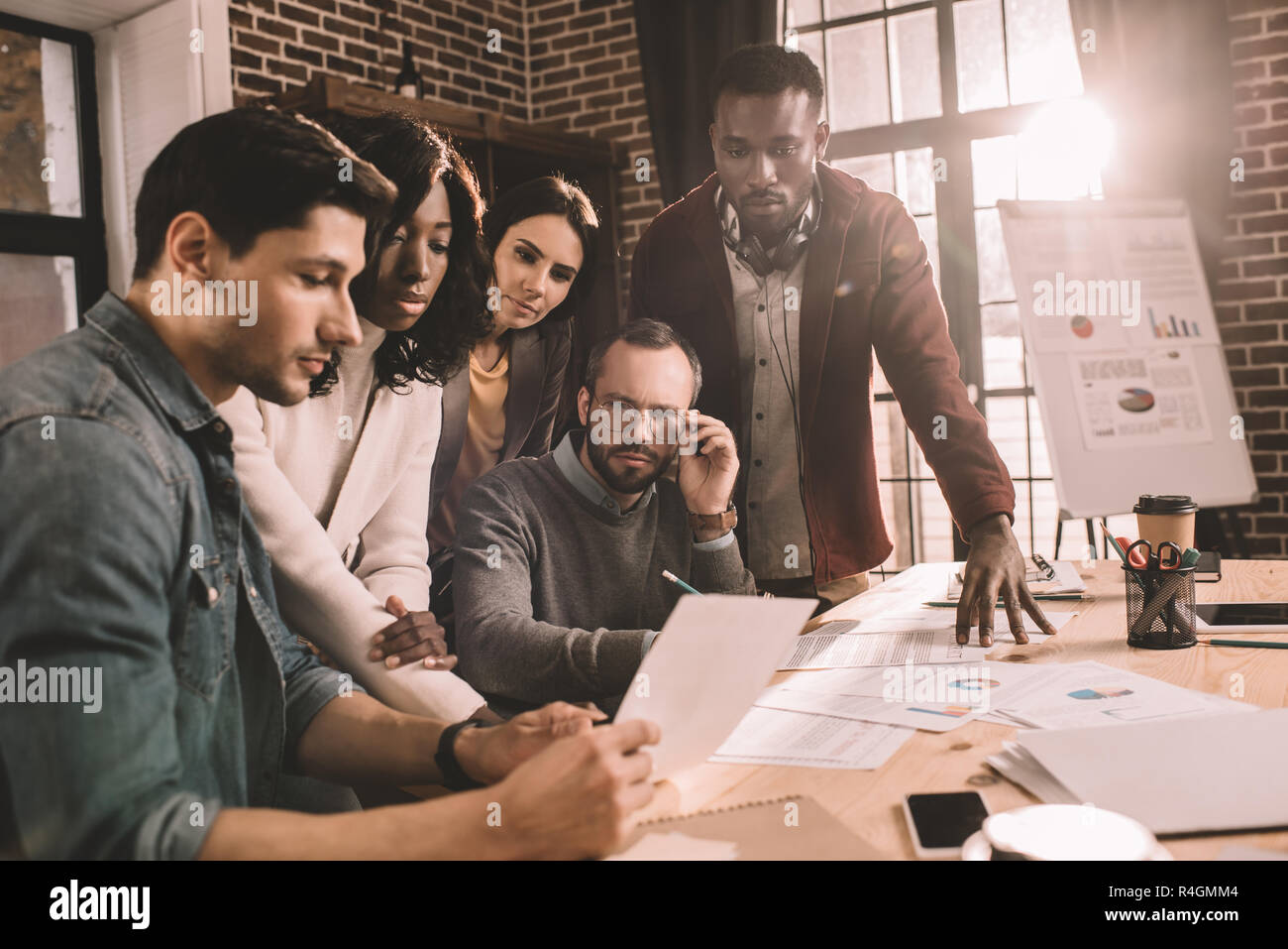 serious multiethnic group of colleagues working together on new project ...