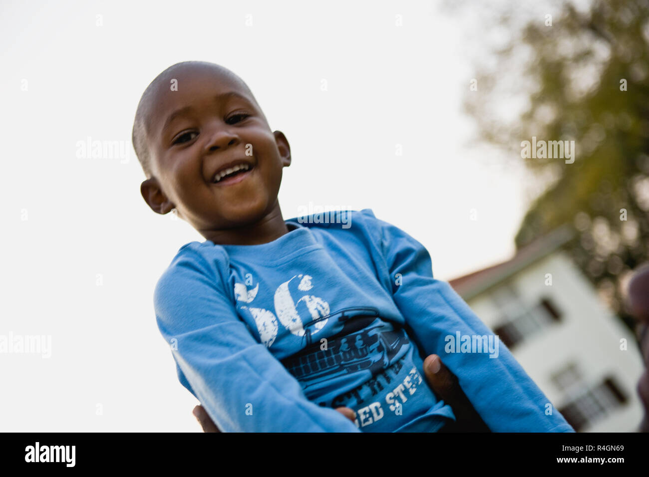 Portrait of a young boy being held up Stock Photo - Alamy