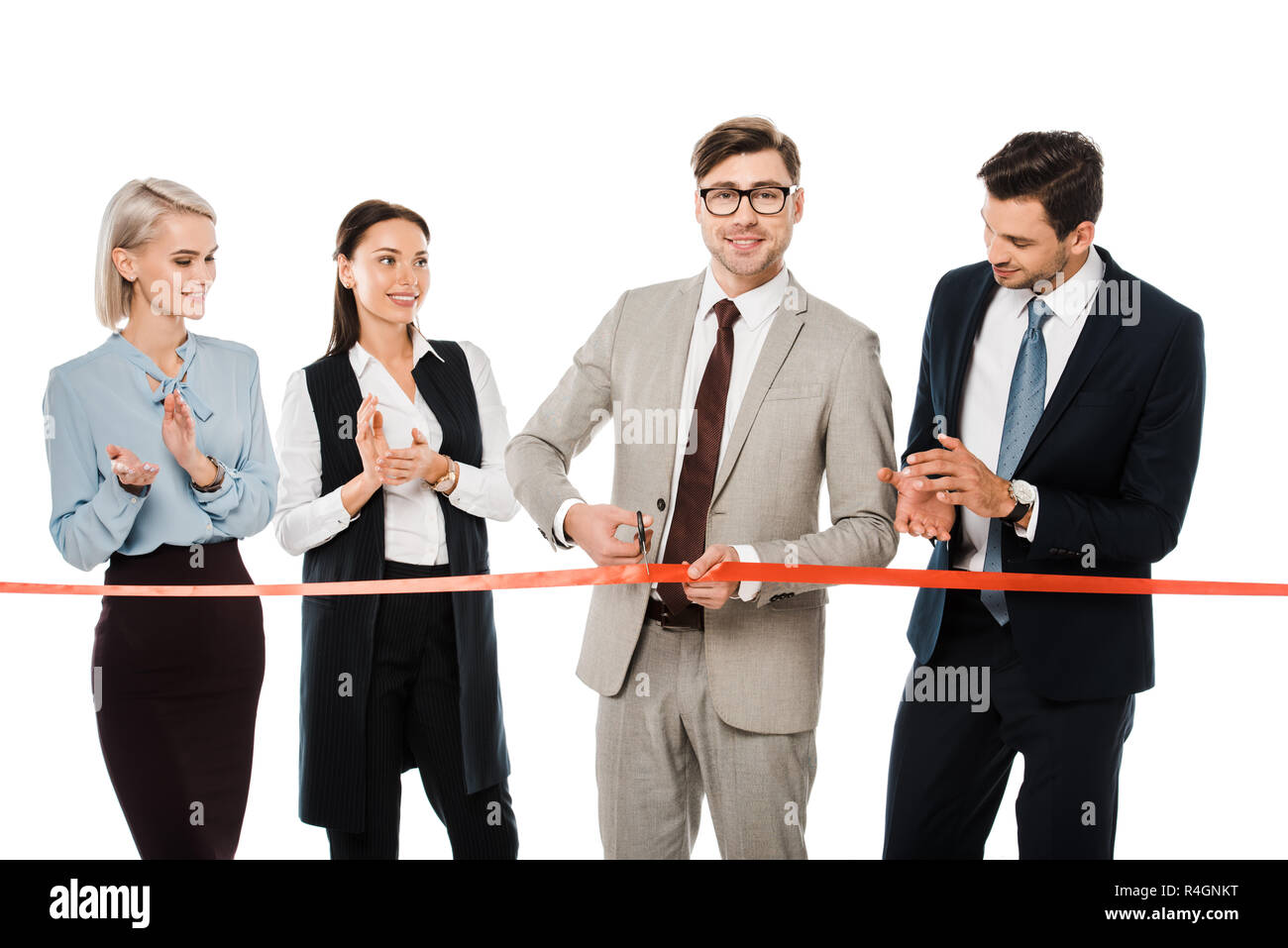 smiling leader cutting red ribbon for grand opening while colleagues ...