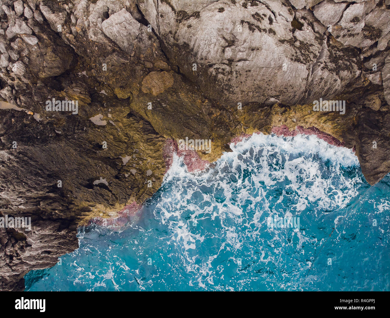 Aerial top view of sea waves hitting rocks Stock Photo - Alamy