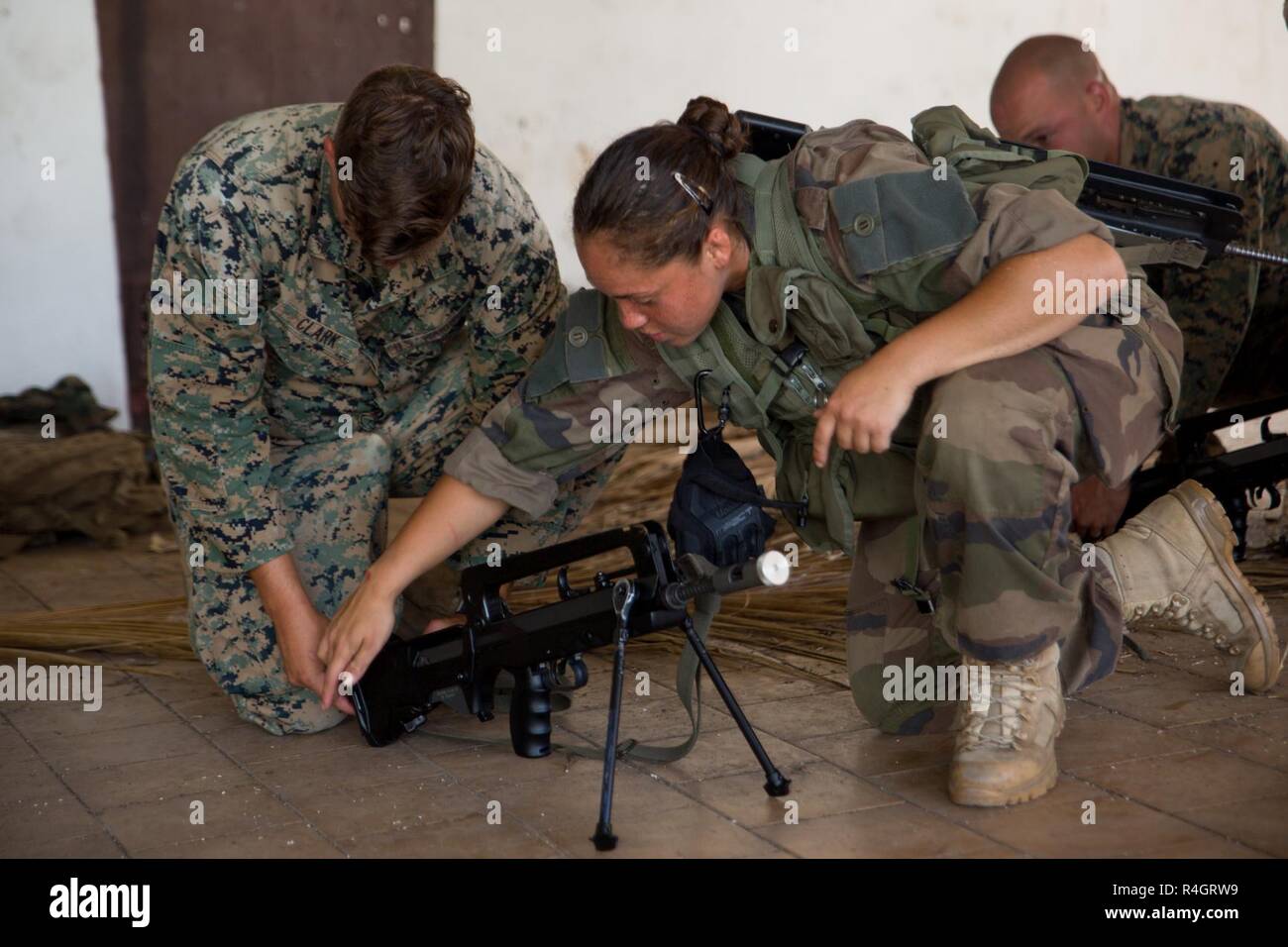 A French Army soldier, right, assists U.S. Marine Corps Cpl. Kyle Clark ...