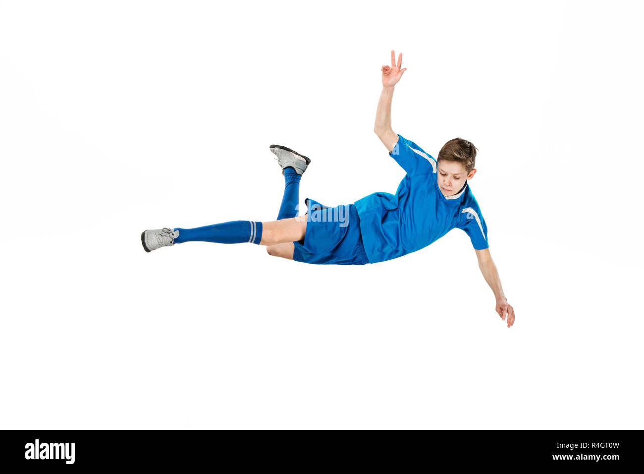 Young boy with soccer ball doing flying kick Stock Photo - Alamy