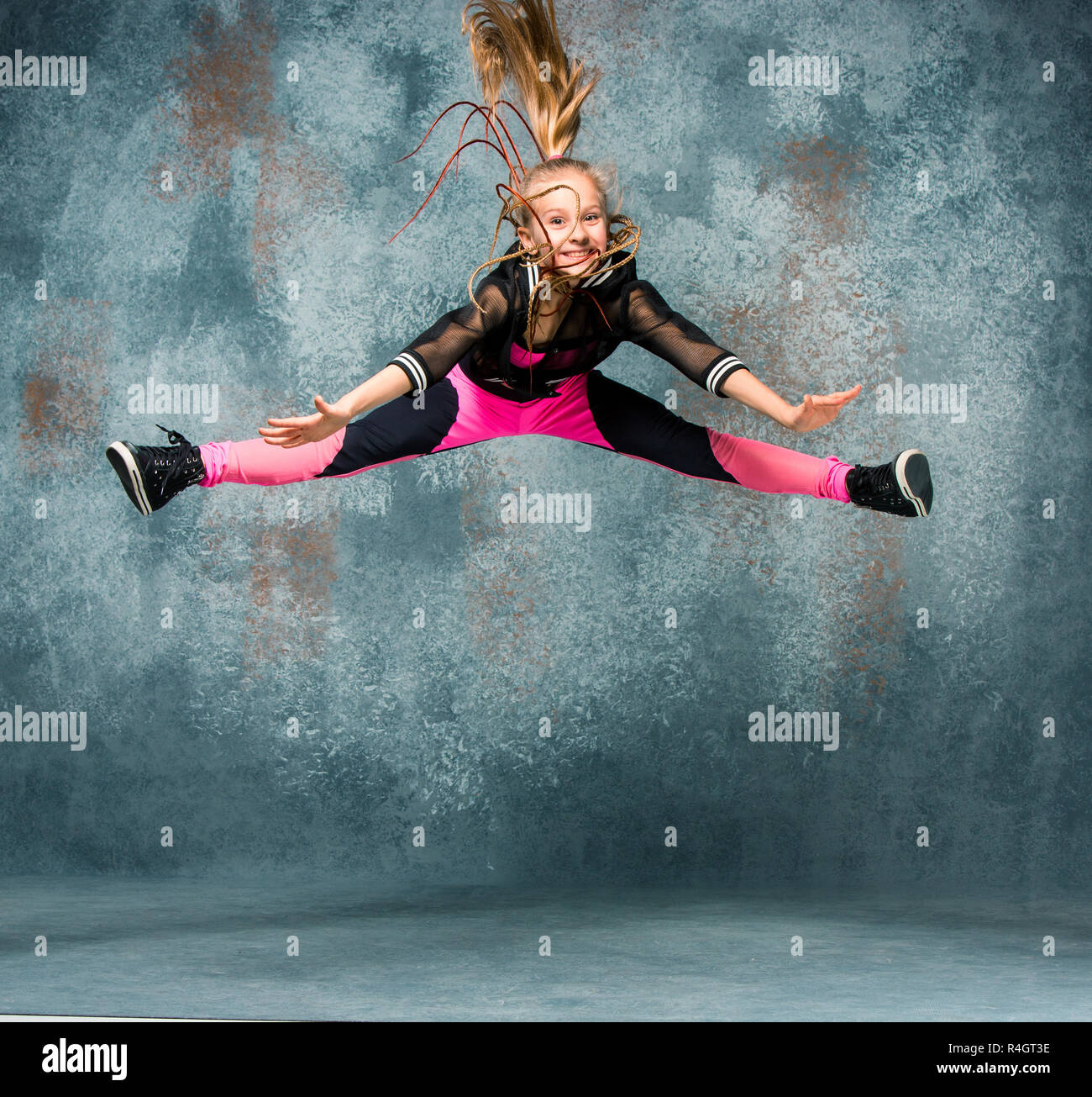 Young girl break dancing on wall background Stock Photo - Alamy