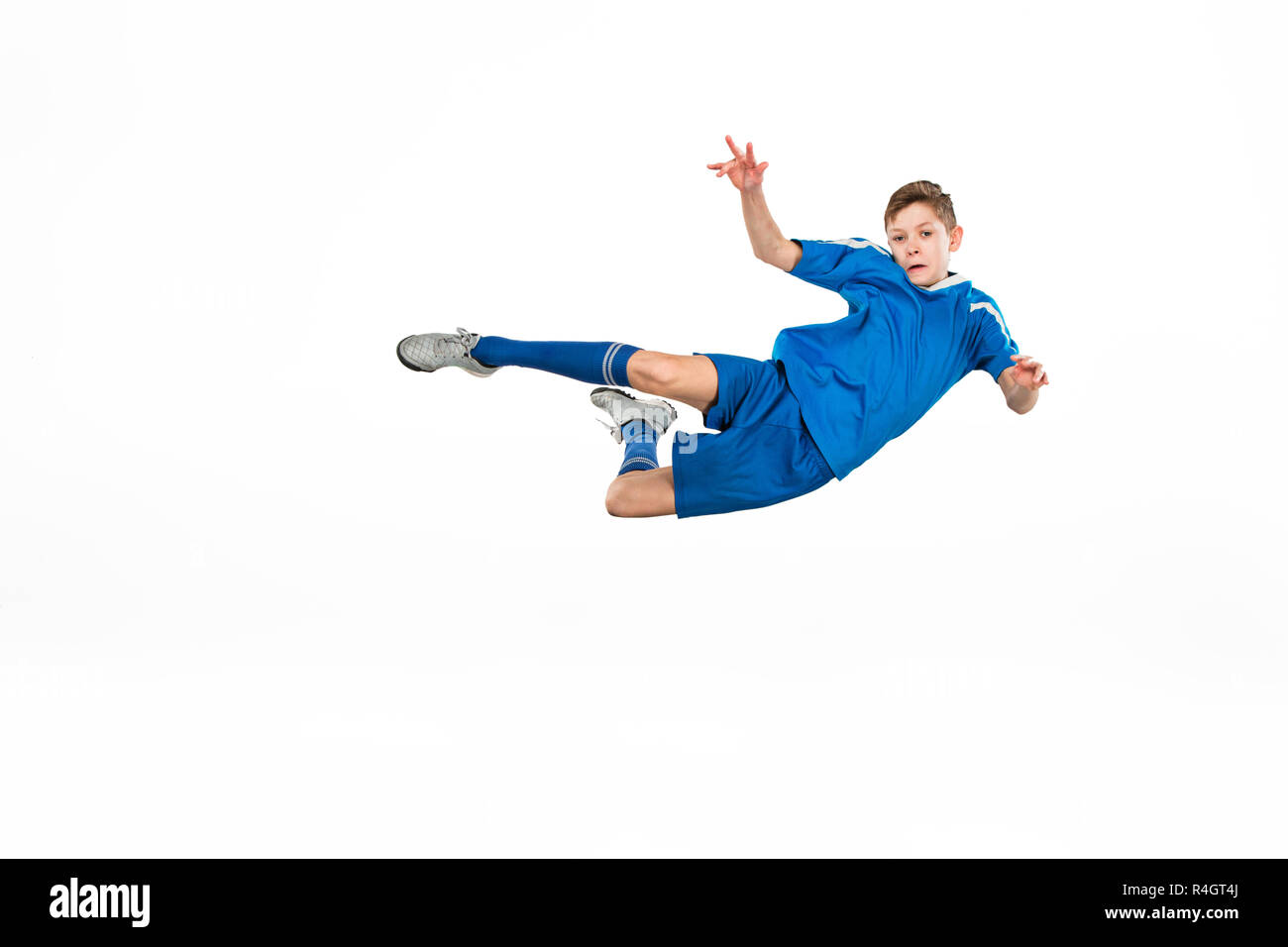 Young boy with soccer ball doing flying kick Stock Photo - Alamy
