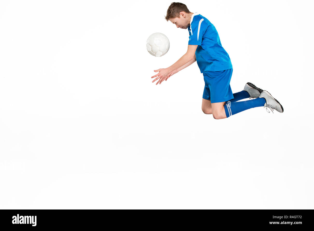 Young boy with soccer ball doing flying kick Stock Photo - Alamy