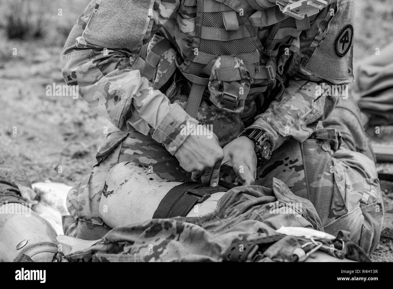 A New Jersey Army National Guard combat medic tightens the tourniquet ...