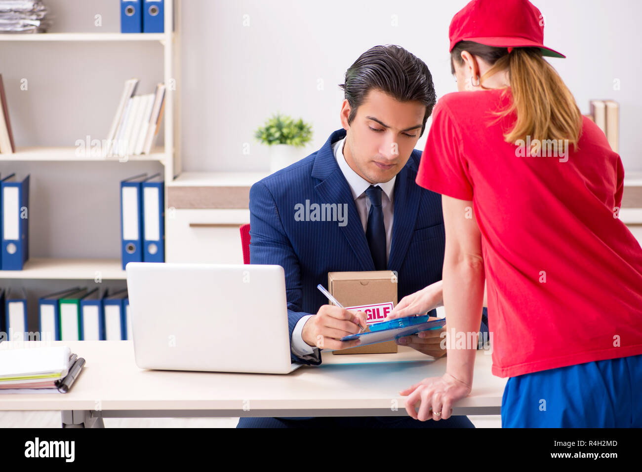 Courier delivering parcel to the office Stock Photo - Alamy