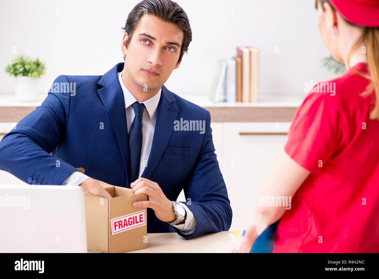 Courier delivering parcel to the office Stock Photo - Alamy