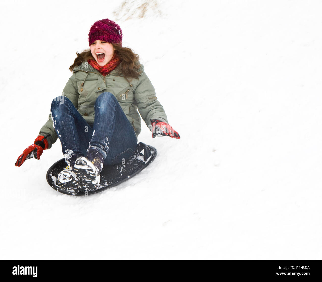 beautiful girl sledging down the hill on snow Stock Photo - Alamy