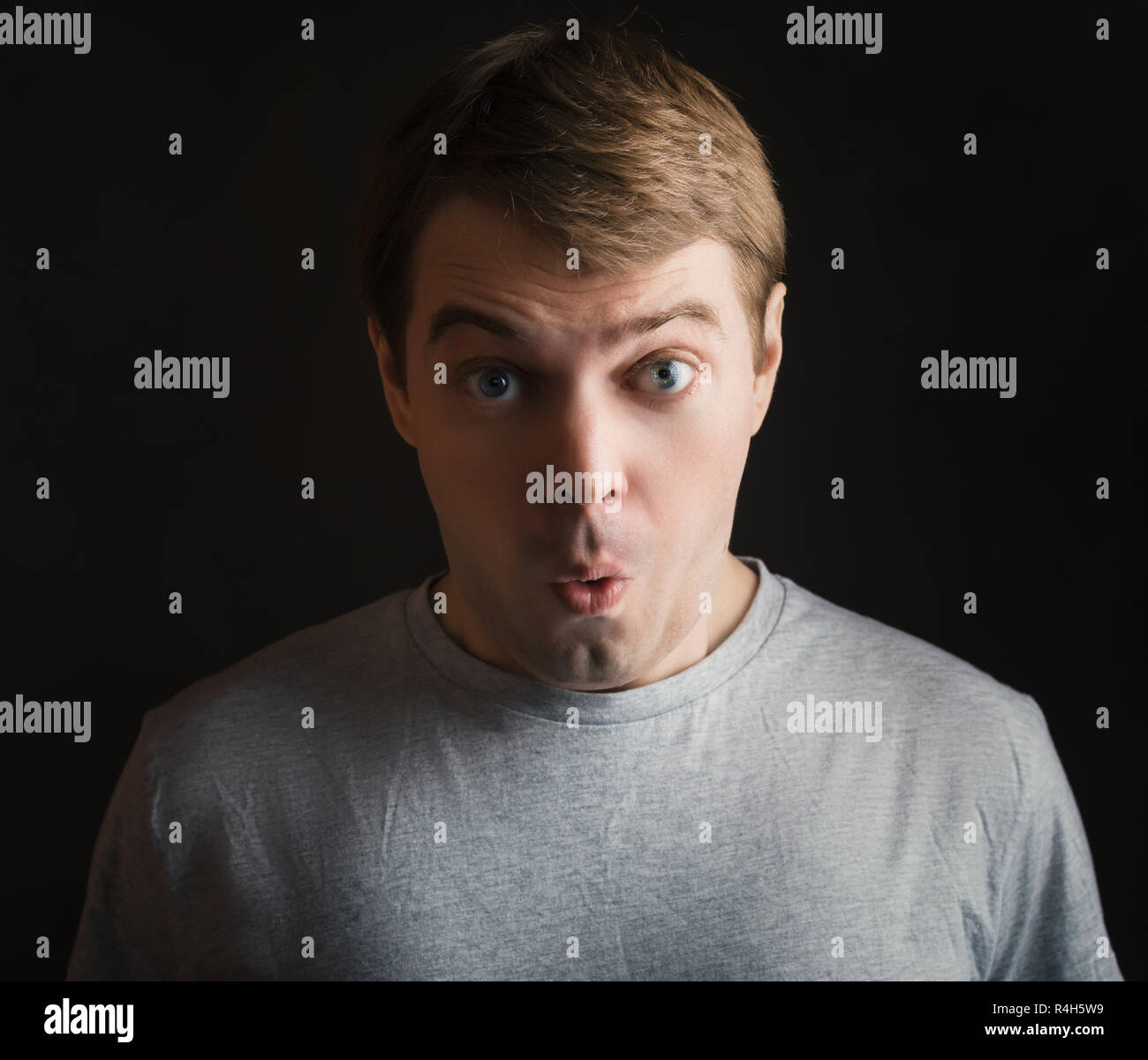 Surprised face. Dark background. Color toned image Stock Photo - Alamy