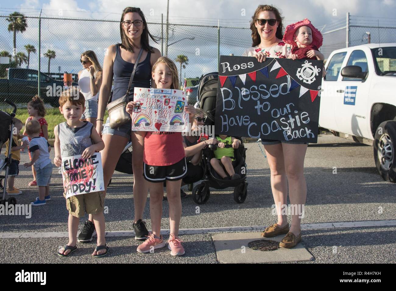 Family members hold up signs and watch as the Coast Guard Cutter ...