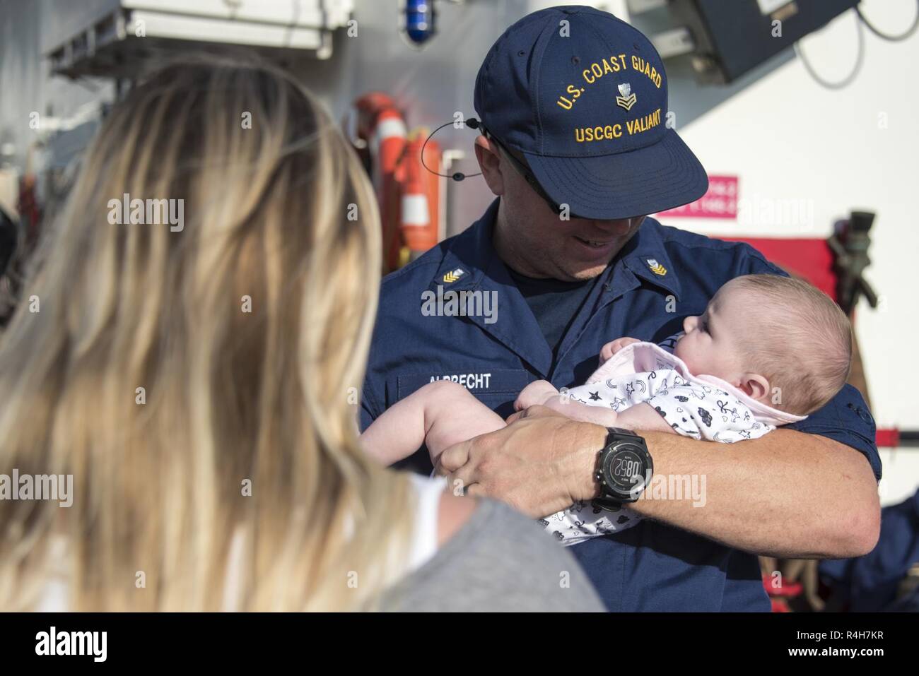 A Coast Guard Cutter Valiant crew member embraces his child Wednesday ...