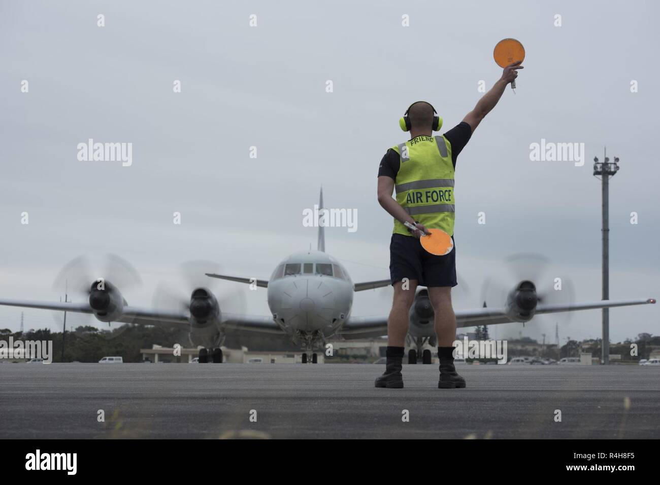 A Royal Australian Air Force member marshals for a RAAF AP-3C Orion ...