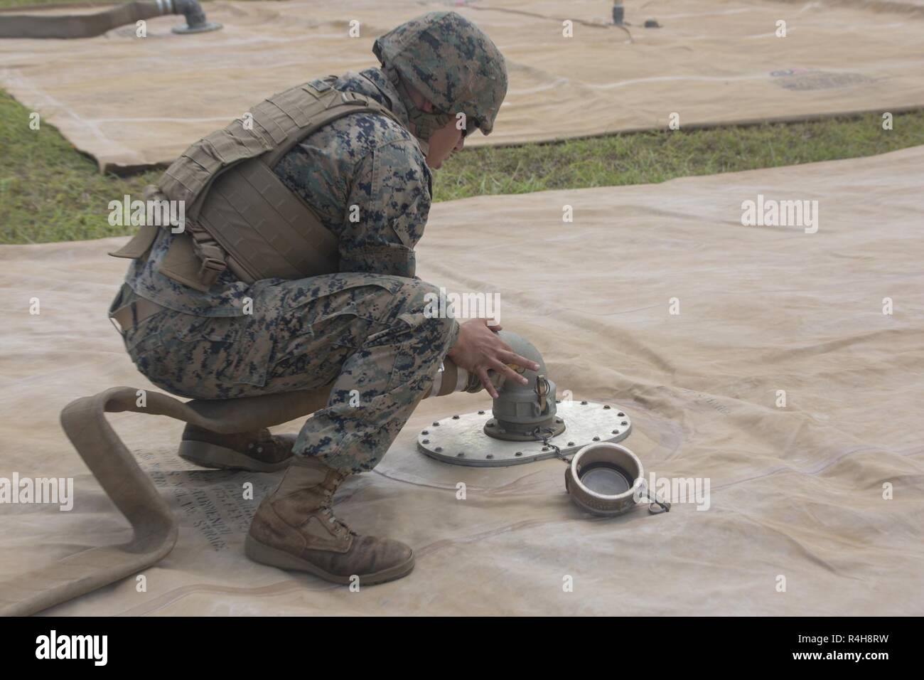 Lance Cpl. Daniel D. Cruz connects a fuel hose to a collapsible fuel ...