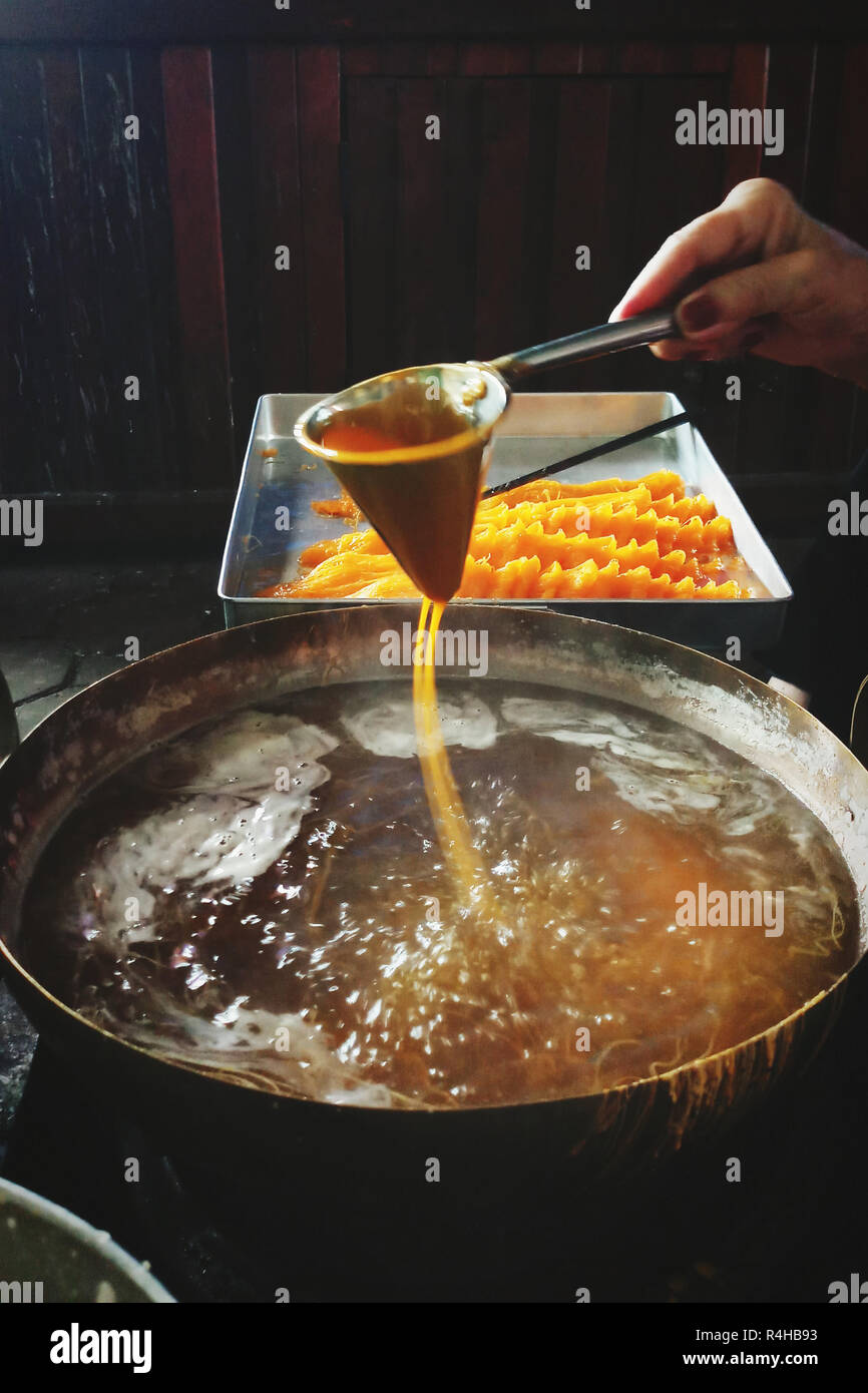 Hand are making of traditional Thai dessert, Foi Thong or Golden Egg ...