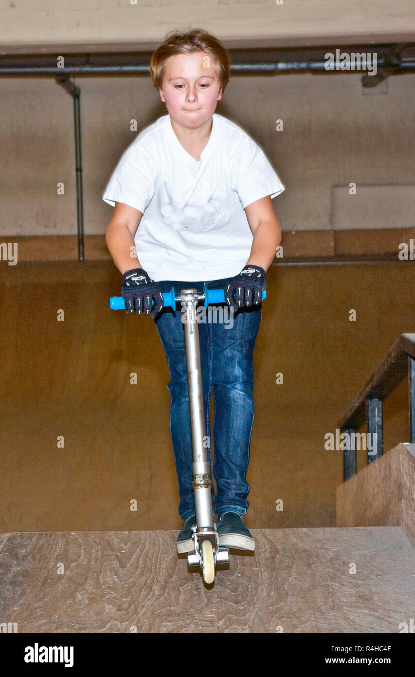 boy is scooting with his scooter in a indoor hall Stock Photo - Alamy