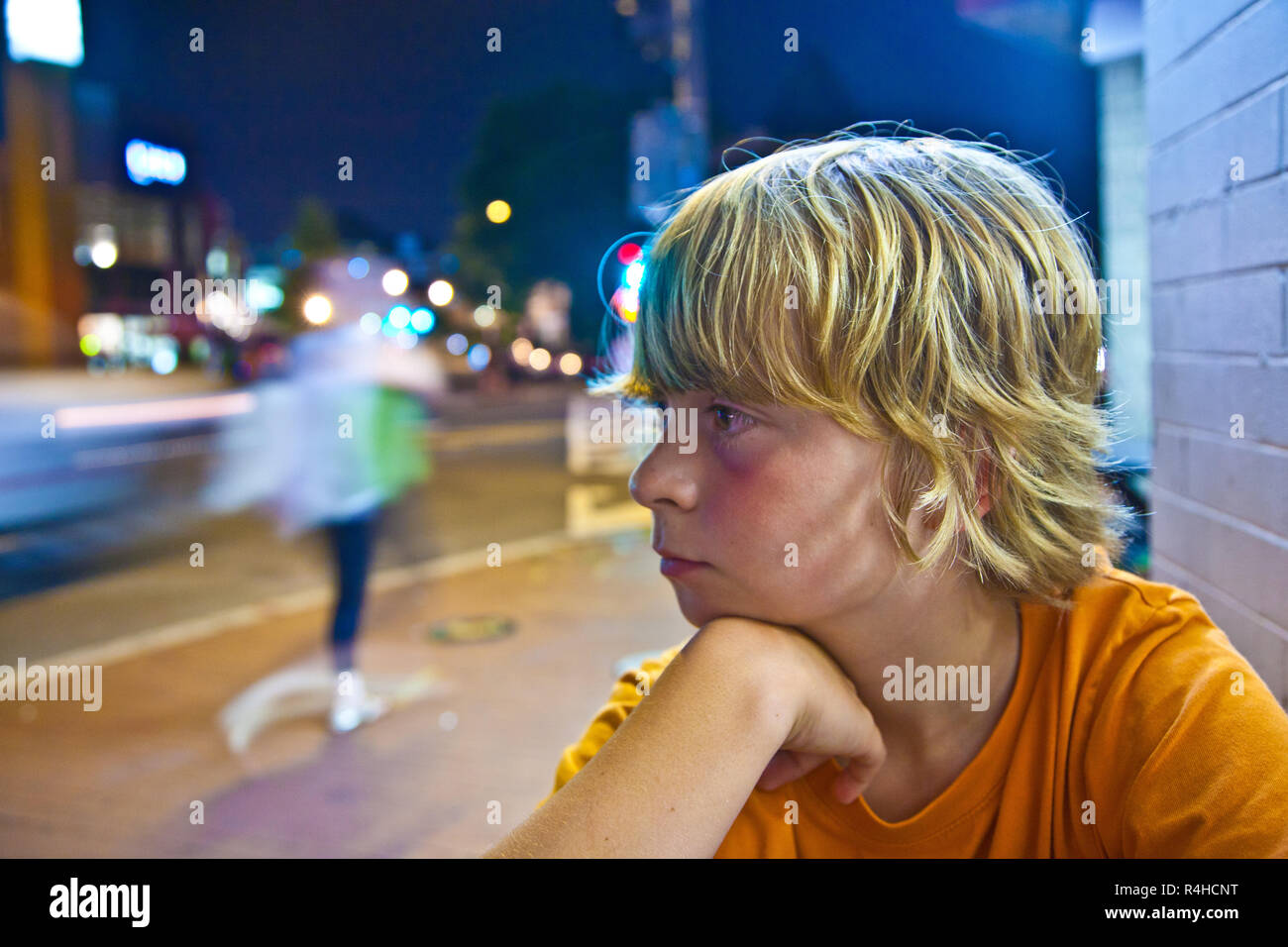 cute boy smiles tired while sitting outside by night Stock Photo - Alamy