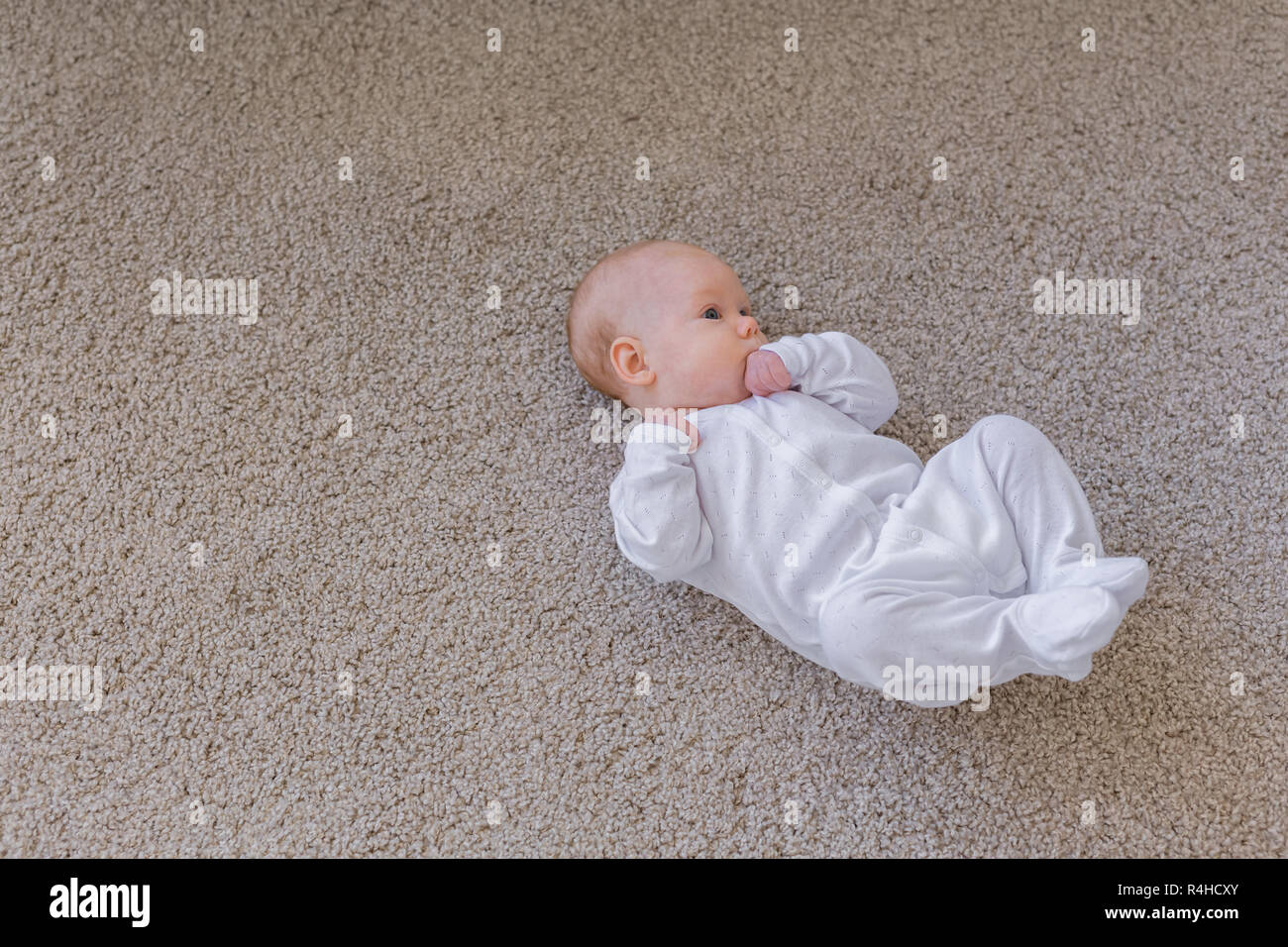 childhood, people concept - baby lies on his back on the floor and ...