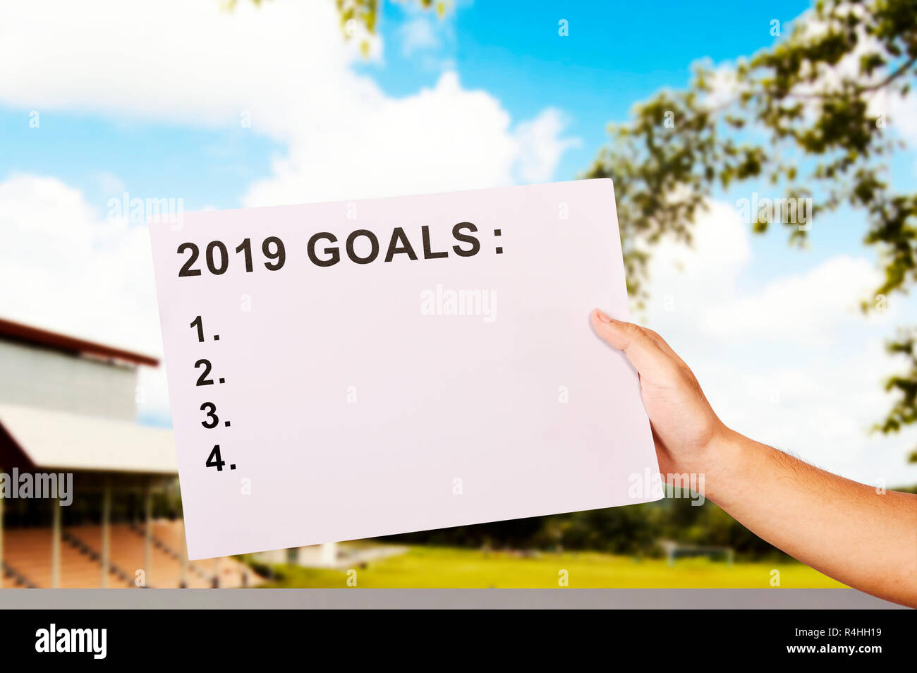Male hands holding white paper with list of 2019 goals. Happy New Year ...