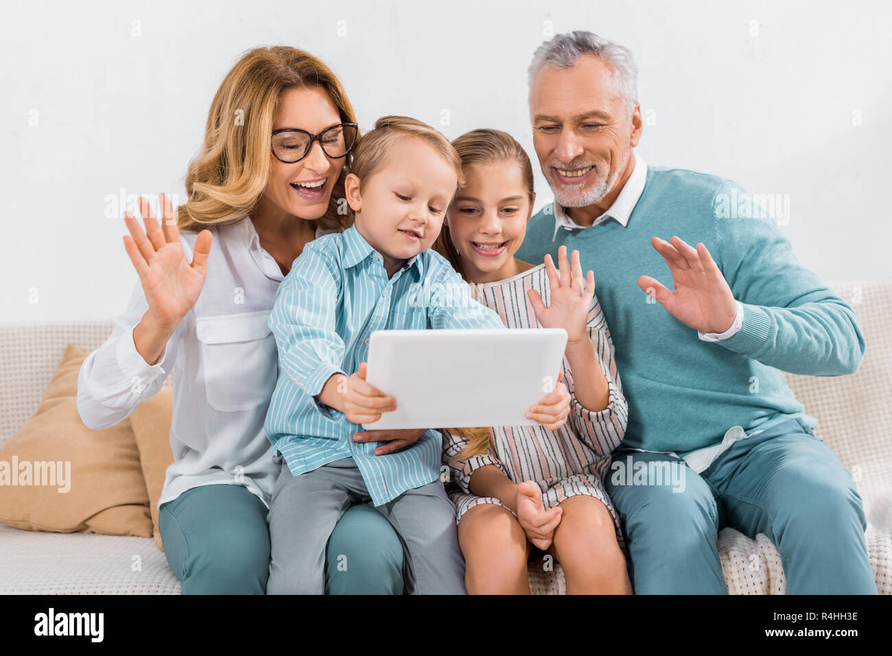 grandchildren and grandparents waving by hands while having video call ...