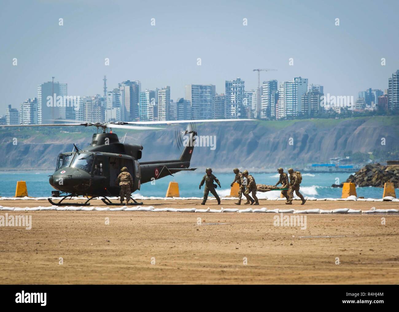 Peruvian airmen transport a simulated casualty into a helicopter during ...