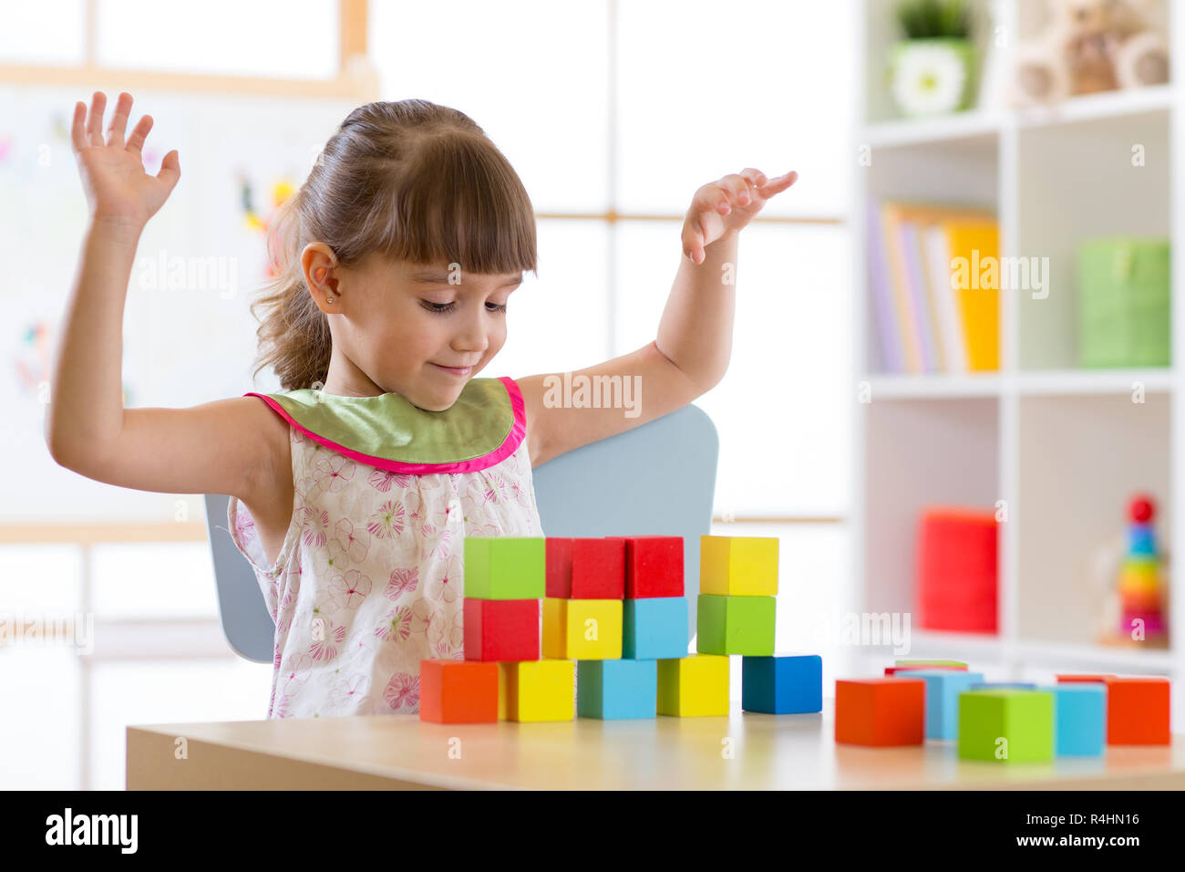 Little girl build block toys at home or daycare. Cheerful kid playing ...