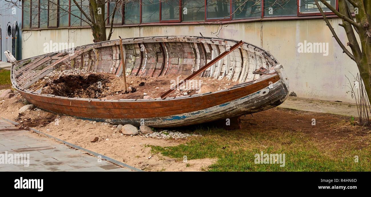 wooden boat destroyed a brick wall near an old and ruined Stock Photo ...