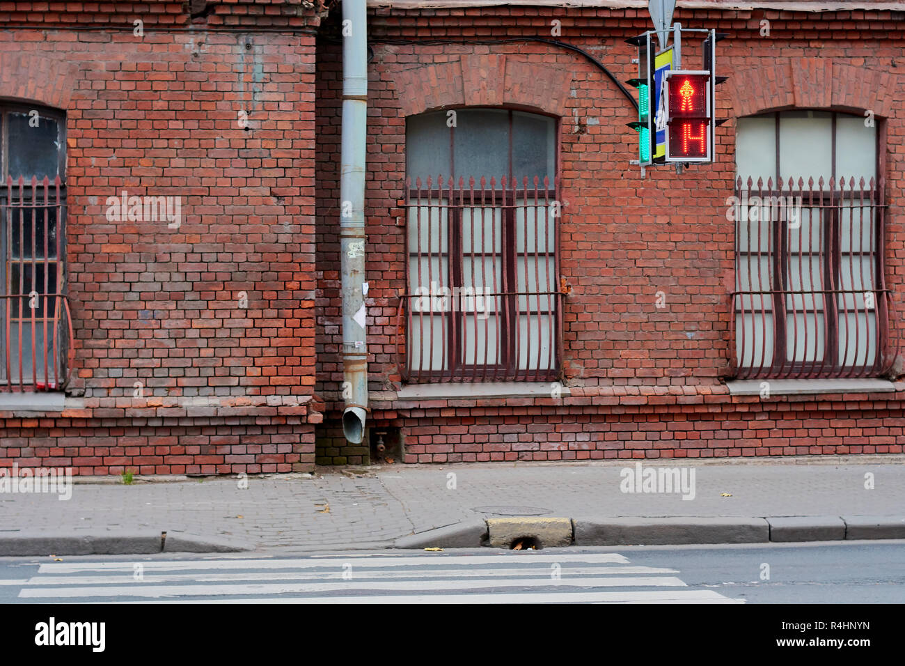pedestrian crossing with red brick building and red traffic light Stock ...