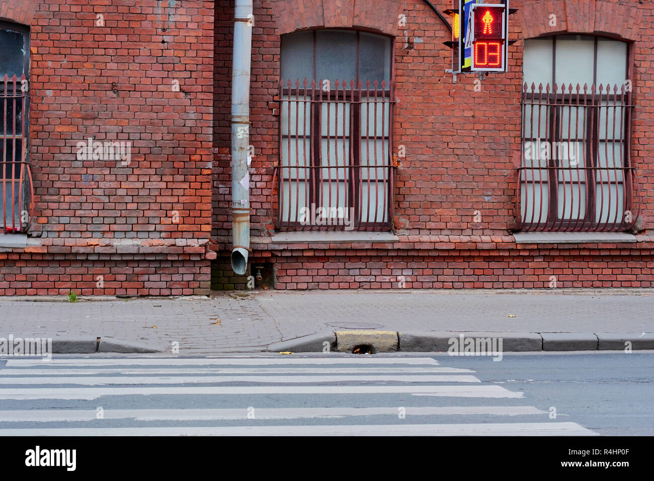 pedestrian crossing with red brick building and red traffic light Stock ...