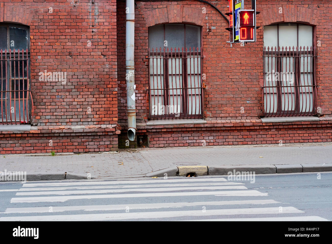 pedestrian crossing with red brick building and red traffic light Stock ...