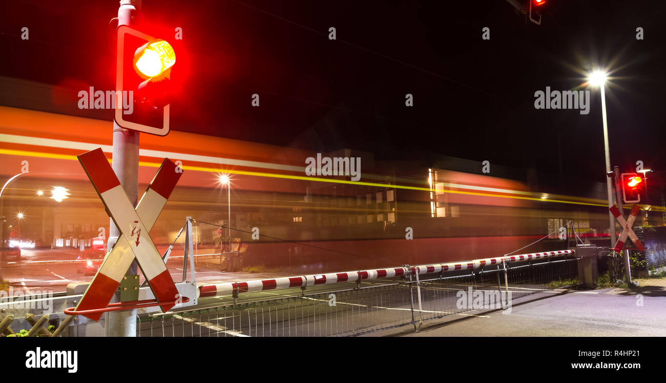 closed railroad crossing with passing train at night panorama Stock ...