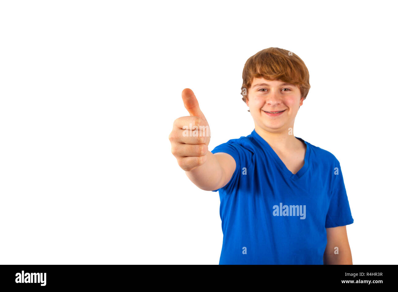 A smiling boy is showing his thumb up isolated on the white background ...